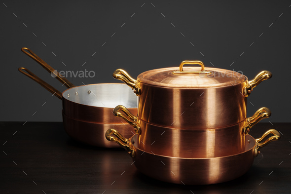 Shiny vintage copper cookware over dark background Stock Photo by ...