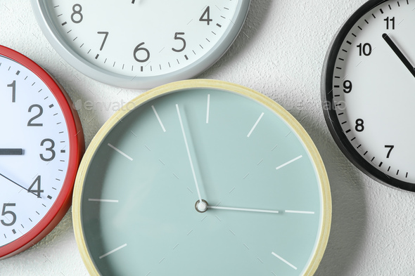 Different beautiful clocks hanging on light wall, closeup Stock Photo ...