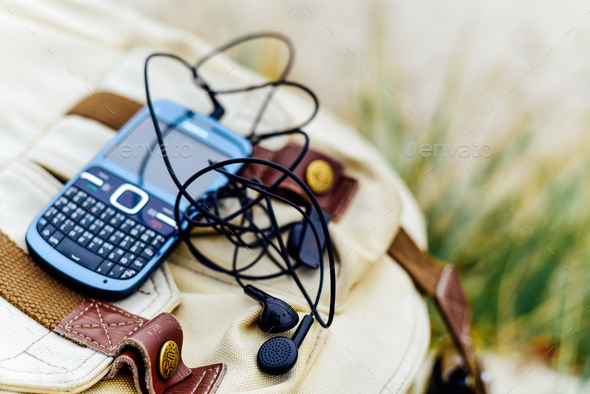 Old fashioned mobile phone with headphones Stock Photo by molenira