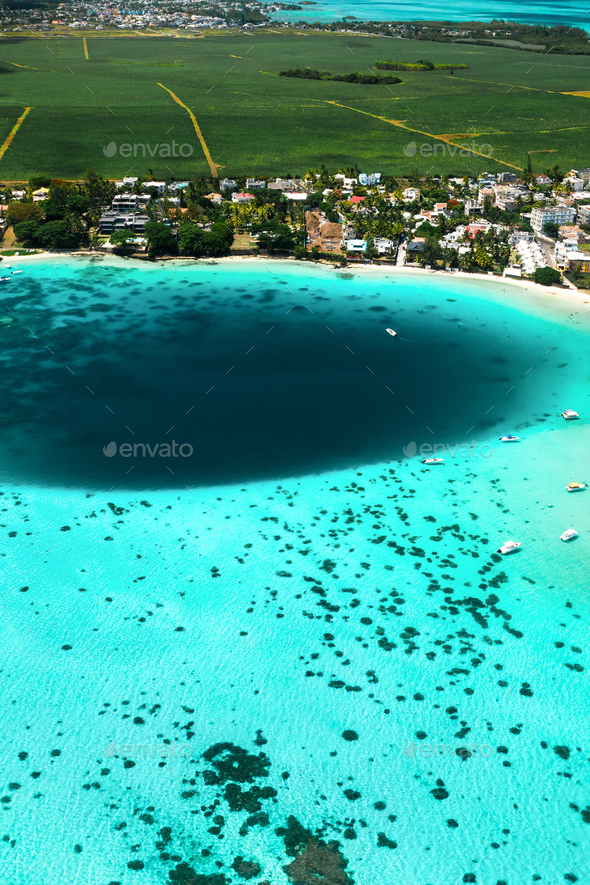 Top view of the Blue Bay lagoon of Mauritius. A boat floats on a ...