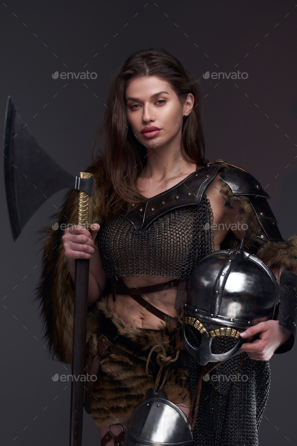 Warlike northern woman with brown hairs and axe Stock Photo by fxquadro