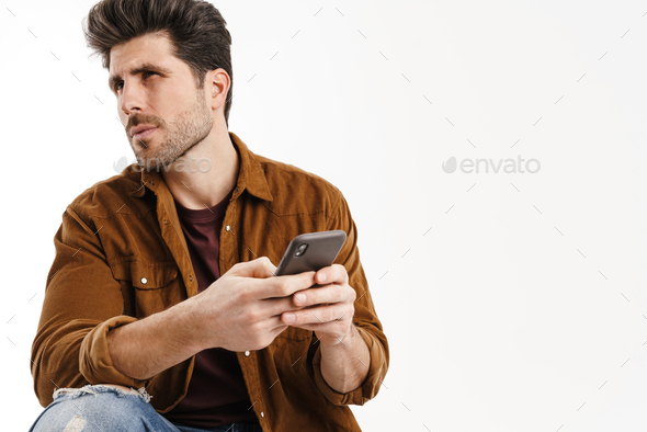 Masculine brooding man looking aside while using cellphone Stock Photo ...