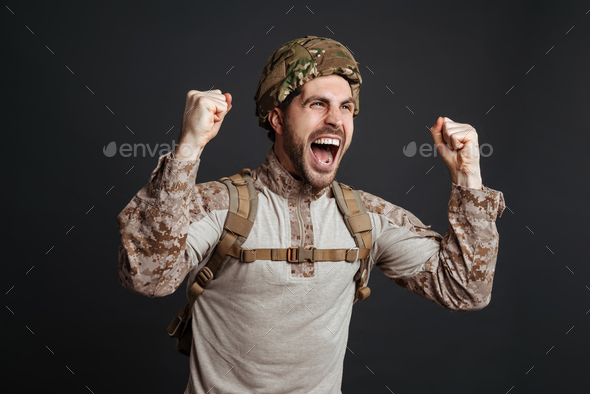 Excited military man in helmet screaming and making winner gesture ...