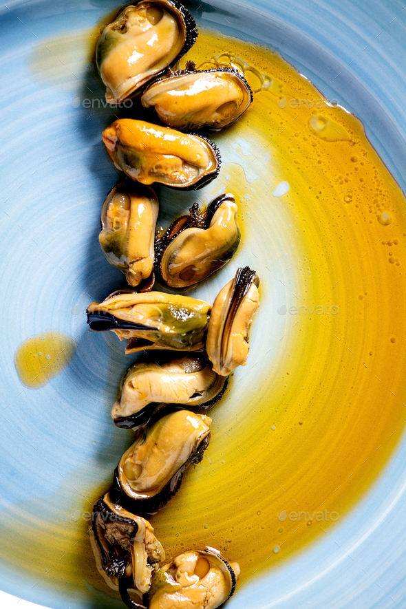 Smoked mussels in oil on blue ceramic plate Stock Photo by NatashaBreen