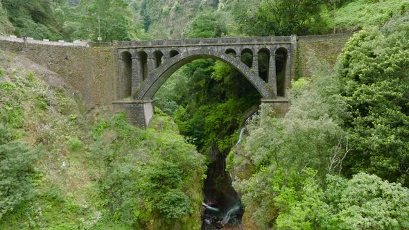 Old arch bridge over ravine in Madeira interior, A Ponte Velha; drone ...