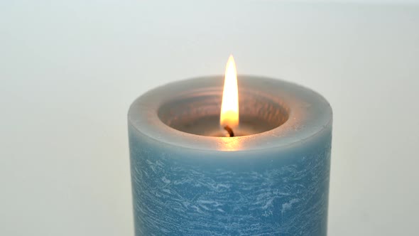 Light blue candle with flame isolated on white background ORBIT SHOT ...