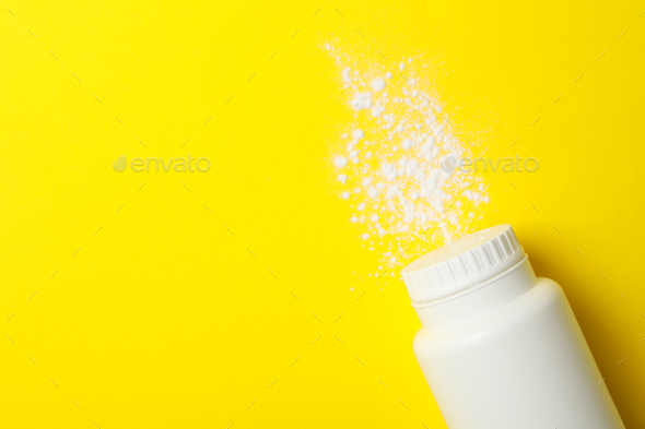 Blank bottle of talcum powder on yellow background, space for text ...