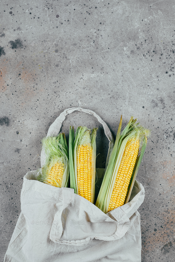 Fresh corn on cobs in a tissue bag. Zero waste concept. Top view, copy ...