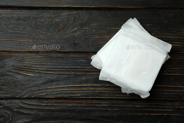 Stack of sanitary pads on wooden background Stock Photo by AtlasComposer