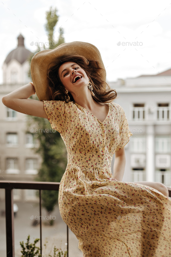 Exciting woman in stylish flower clothes laughing on terrace. Gorgeous ...