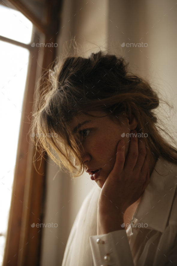 Beautiful woman with sloppy hairstyle in transparent outfit looking ...