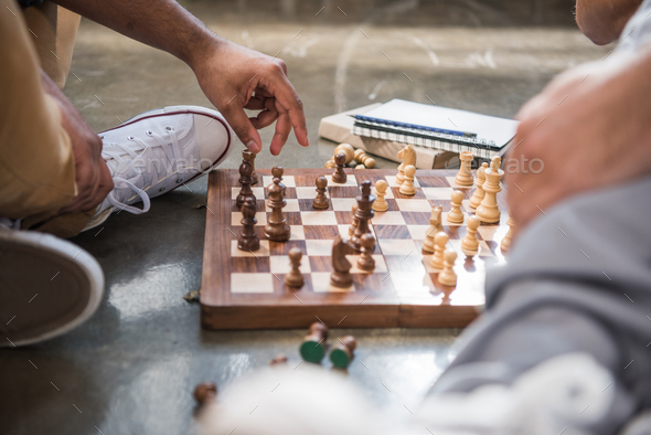 young men sitting on floor and playing chess on chess board Stock Photo ...