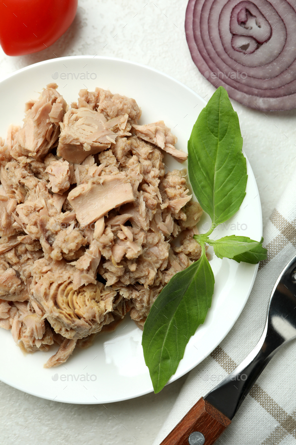 Concept of tasty eating with canned tuna on white textured background ...