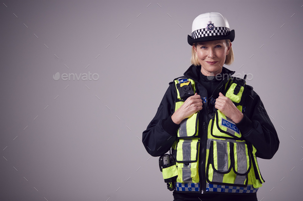 Studio Portrait Of Smiling Mature Female Police Officer Wearing Hat ...
