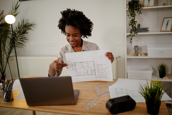 Interior African American designer talking with client at video call ...
