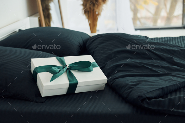 Gift box on bed. Interior and design of beautiful modern bedroom at ...