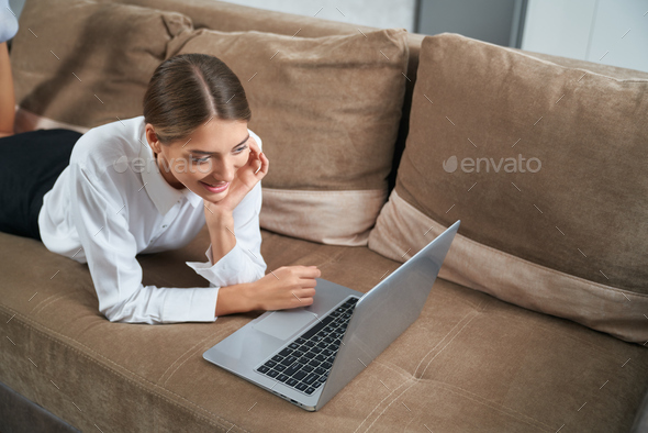 Adorable lady using laptop during free time at home Stock Photo by ...