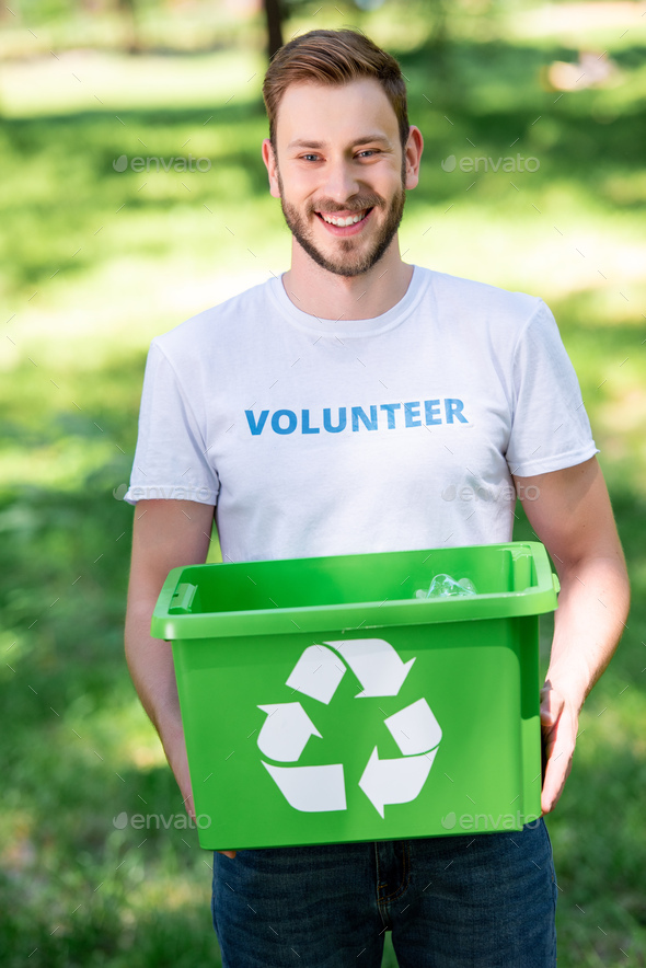 smiling male volunteer holding recycling box with rubbish in park Stock ...