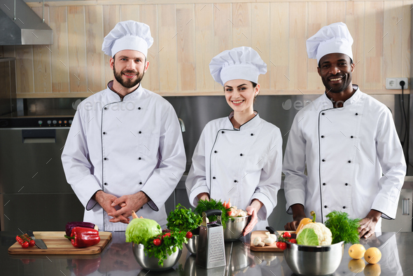 Multiracial chefs team smiling by modern kitchen counter Stock Photo by ...