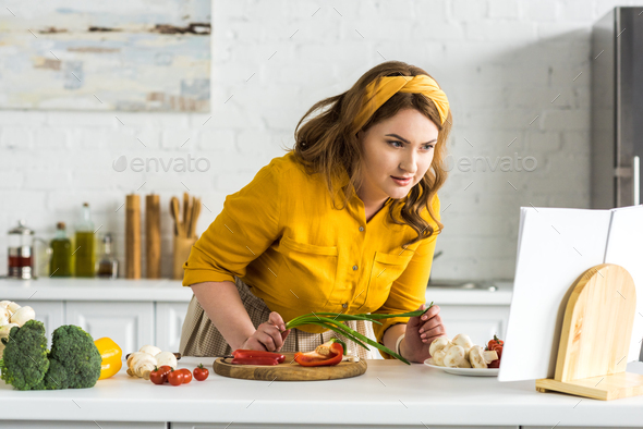 beautiful woman reading recipe in recipe book at kitchen Stock Photo by ...