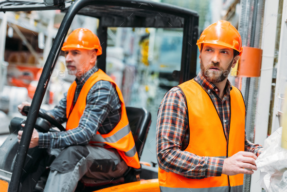 worker and his senior colleague working with forklift machine Stock ...