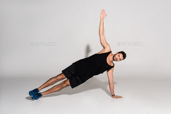 sportive young man doing side plank Stock Photo by LightFieldStudios