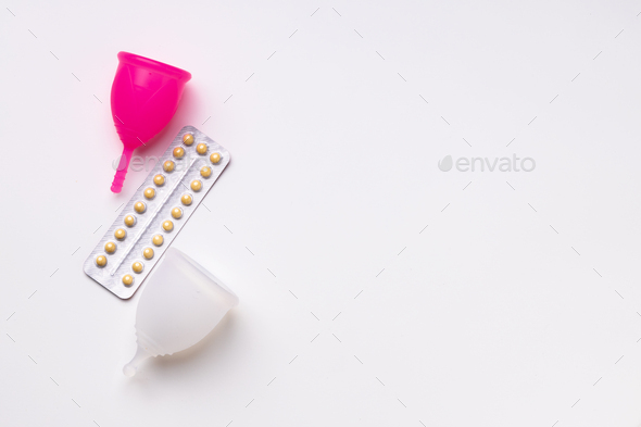 Menstrual cup and oral contraceptive pills top view Stock Photo by ...