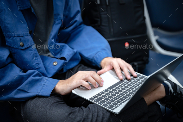 business man sitting and using laptop computer to work at the airport ...