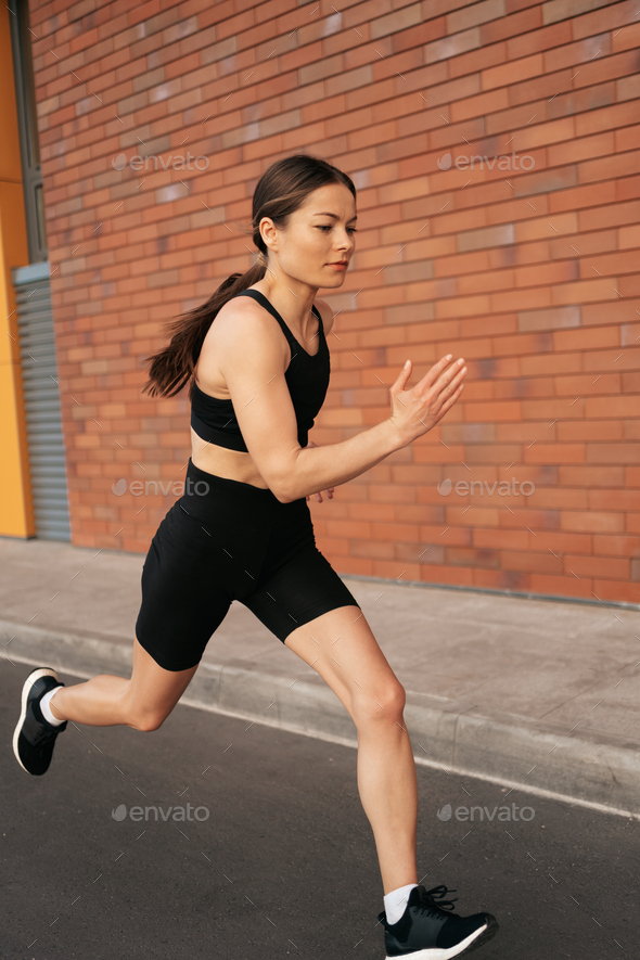 Female fitness model training outside in the city Stock Photo by diignat