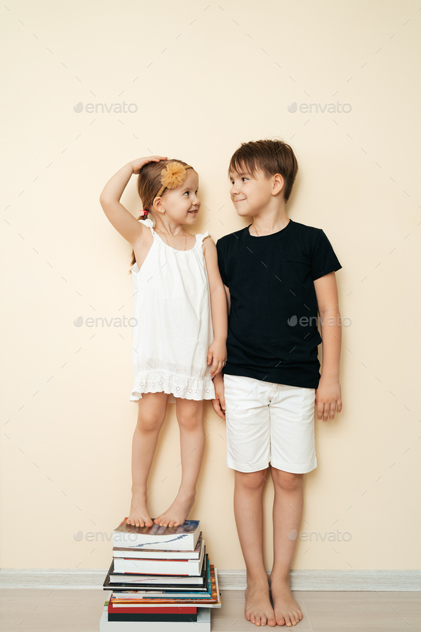 Brother and sister measuring height Stock Photo by diignat | PhotoDune