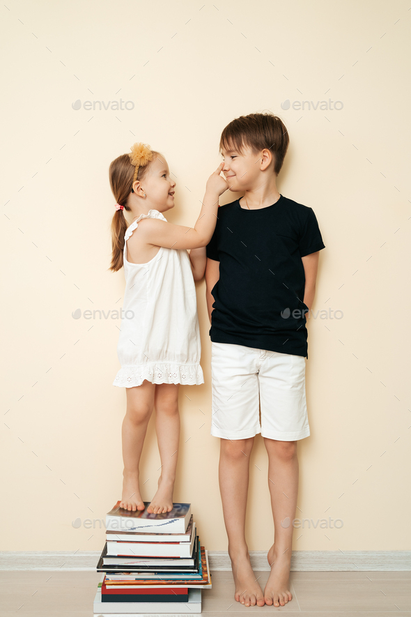Brother and sister measuring height Stock Photo by diignat | PhotoDune