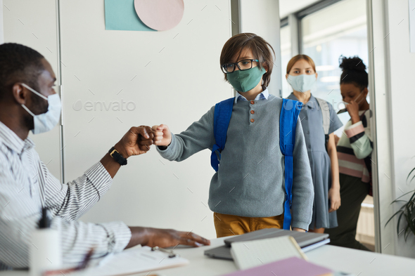 Teacher Greeting Kids in Classroom Stock Photo by seventyfourimages