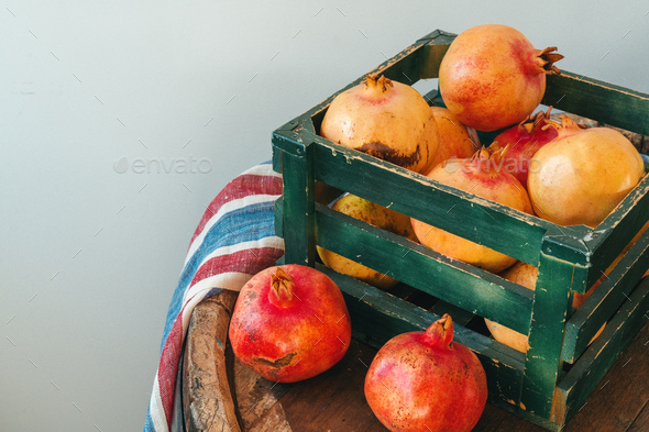 Fresh pomegranates in an old box on wooden background Stock Photo by ...