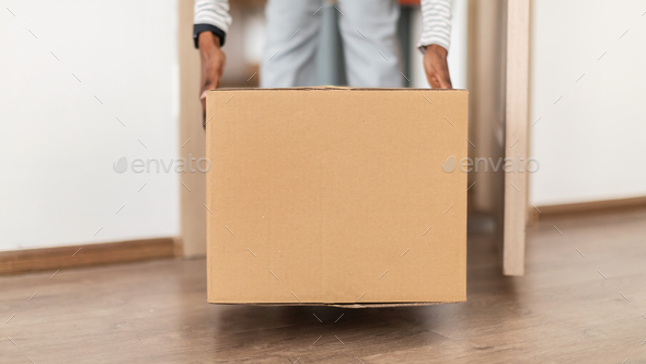 Unrecognizable African Lady Putting Cardboard Box On Floor Entering ...