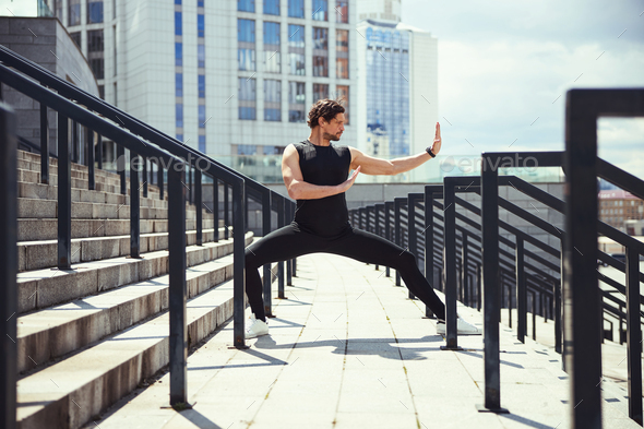 Kind serious man standing in pose of martial arts Stock Photo by Iakobchuk