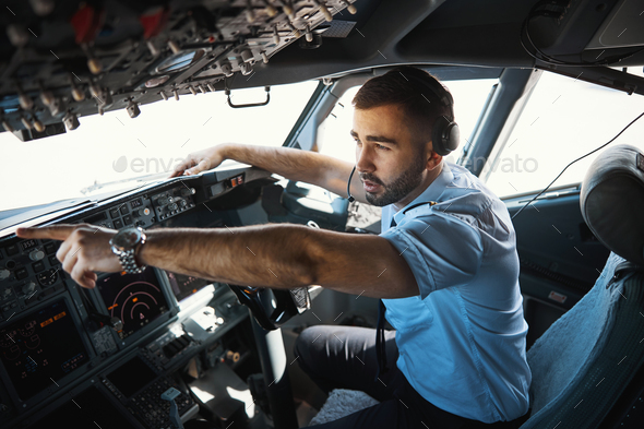 Worried young pilot pointing to something outside the aircraft Stock ...