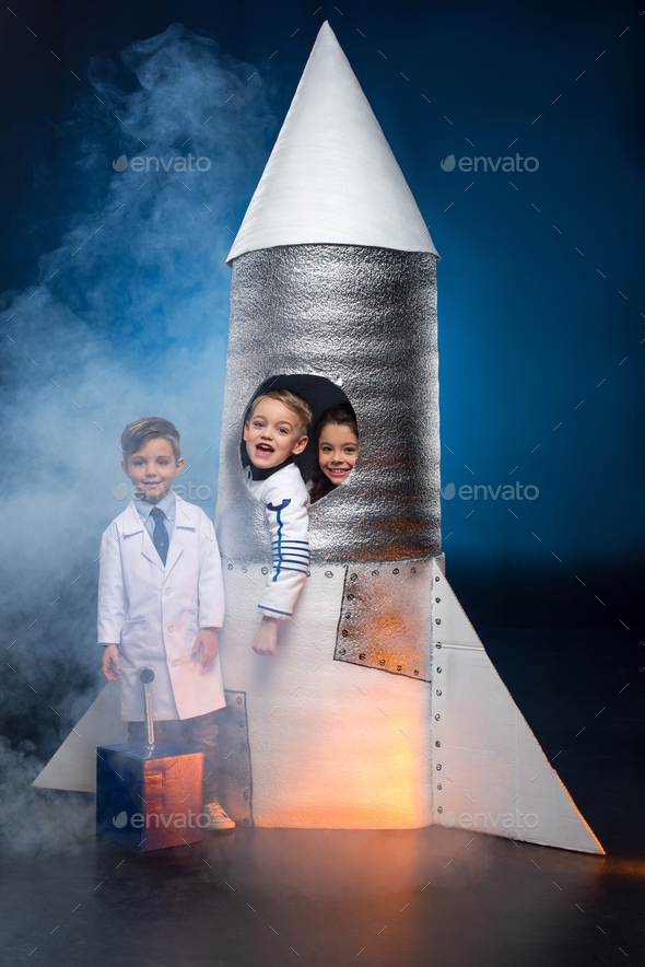 Three adorable little kids playing astronauts and launching spaceship ...