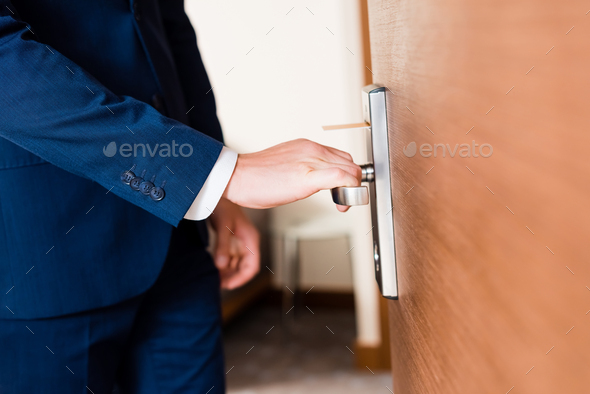 cropped view of man touching door handle while opening door Stock Photo ...