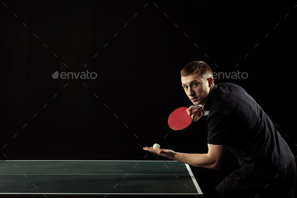 side view of young table tennis player with racket and ball in hands ...