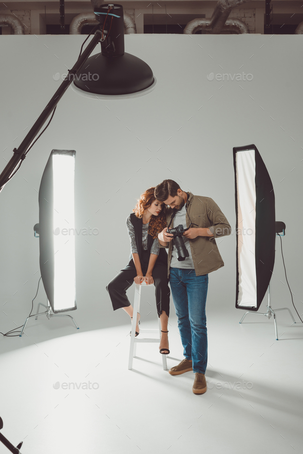 professional photographer showing photos to beautiful model in photo ...