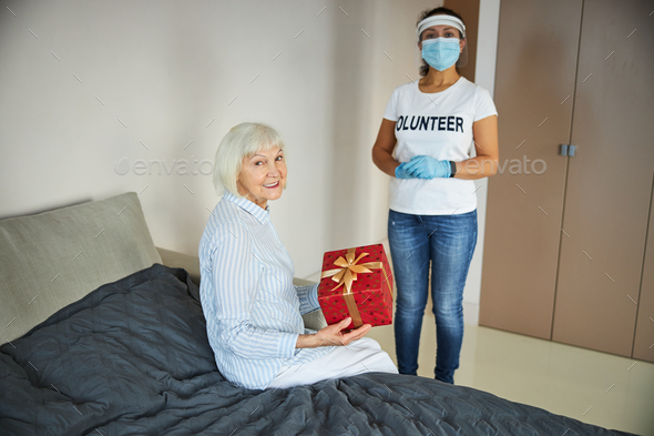 Delighted aging woman is holding a present Stock Photo by Iakobchuk