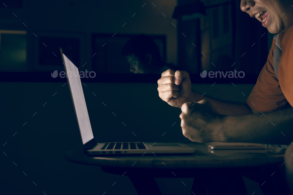People are happy while using the computer at night. Stock Photo by wutzkoh