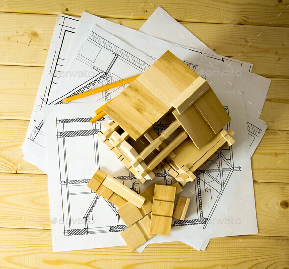 Many drawings for building, pencils and small house on wooden ...