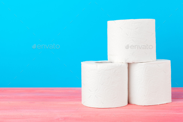 Toilet paper stack on bright blue background Stock Photo by FabrikaPhoto