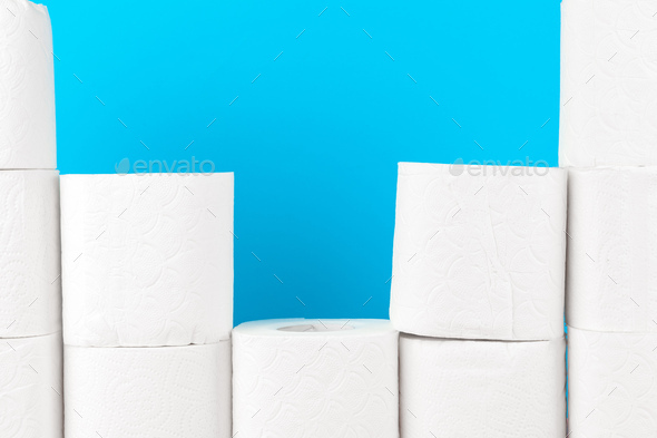 Toilet paper stack on bright blue background Stock Photo by FabrikaPhoto