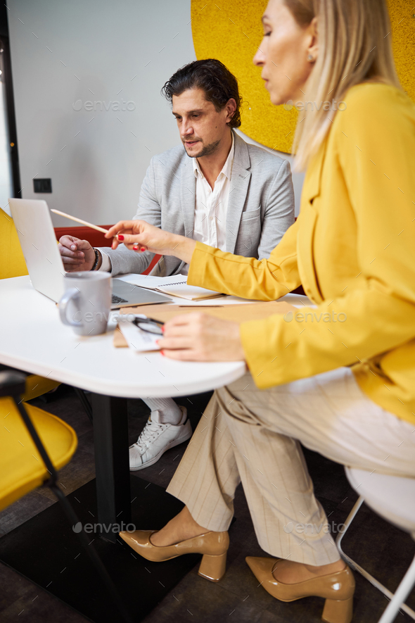 Attentive female person pointing at screen of laptop Stock Photo by ...