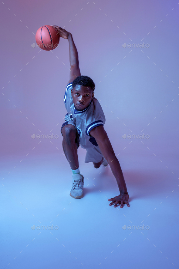 Muscular basketball player with ball shows skill Stock Photo by NomadSoul1
