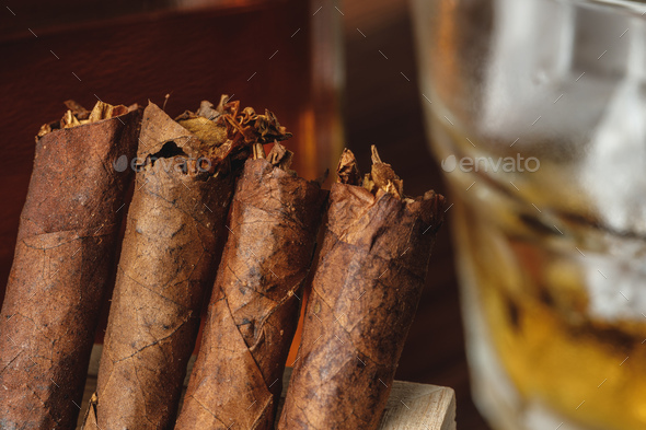 Pile of new cigars close up on wooden table Stock Photo by FabrikaPhoto