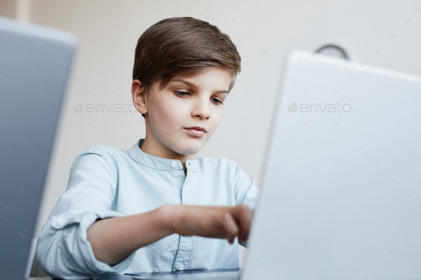 Boy Using Computer in School Stock Photo by seventyfourimages | PhotoDune