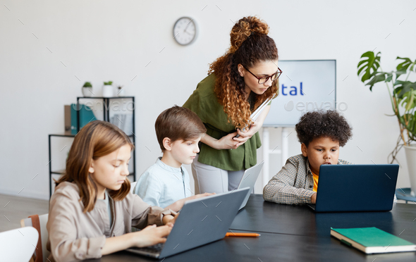 Female Teacher Working with Children in School Stock Photo by ...